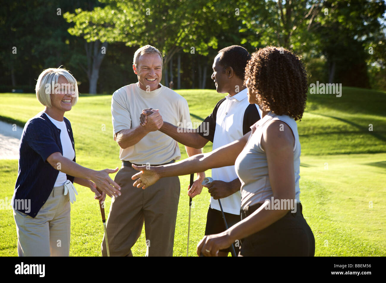 Couples Shaking Hands on Golf Course Stock Photo - Alamy