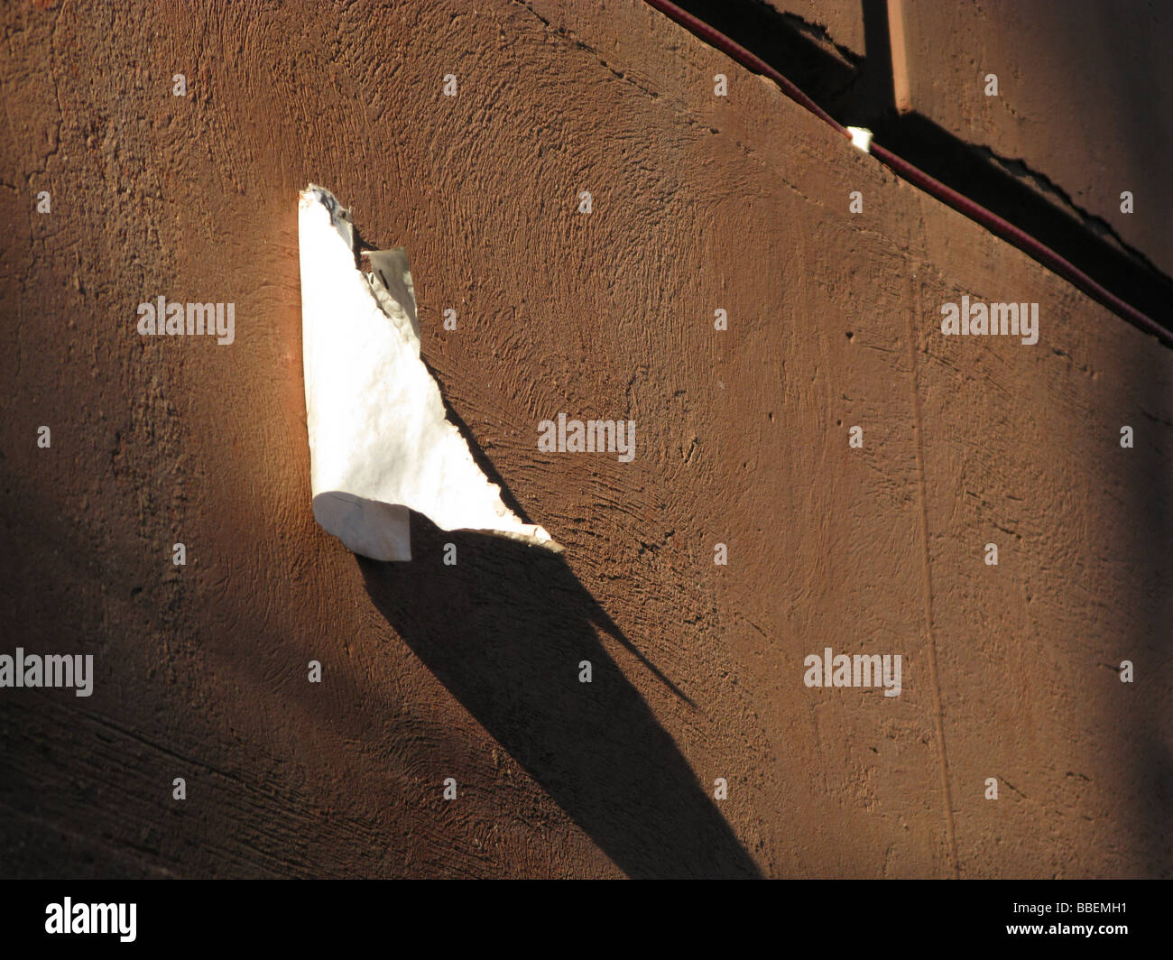 torn sheet of paper stuck to wall in city town Stock Photo - Alamy