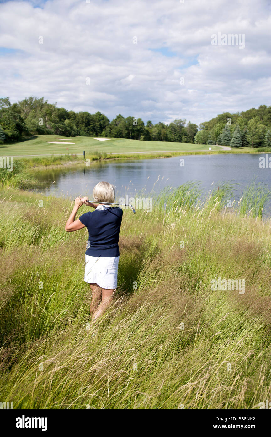 Back View of Woman Golfing in Tall Grass Stock Photo - Alamy