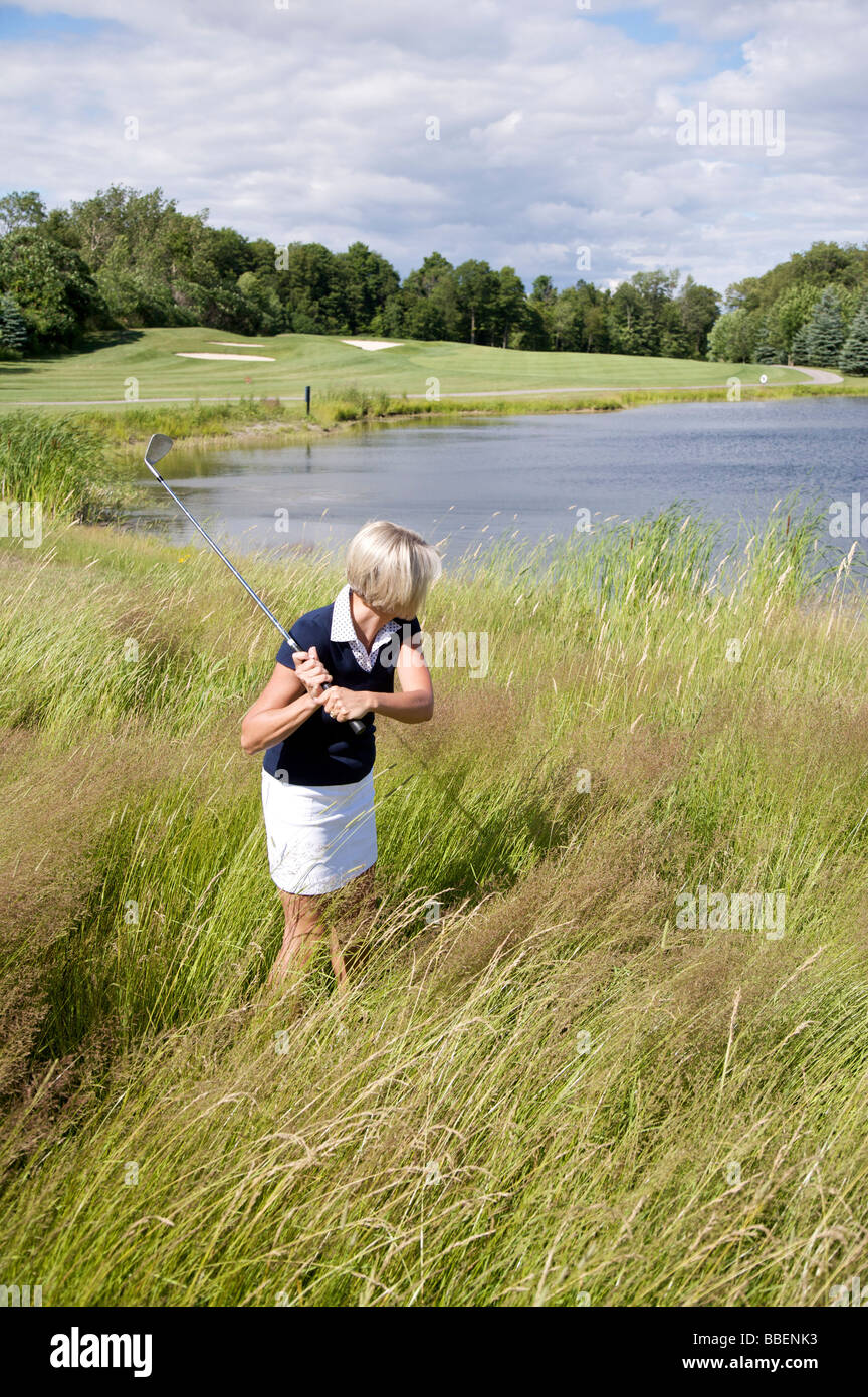 Side View of Woman Golfing in Tall Grass Stock Photo - Alamy