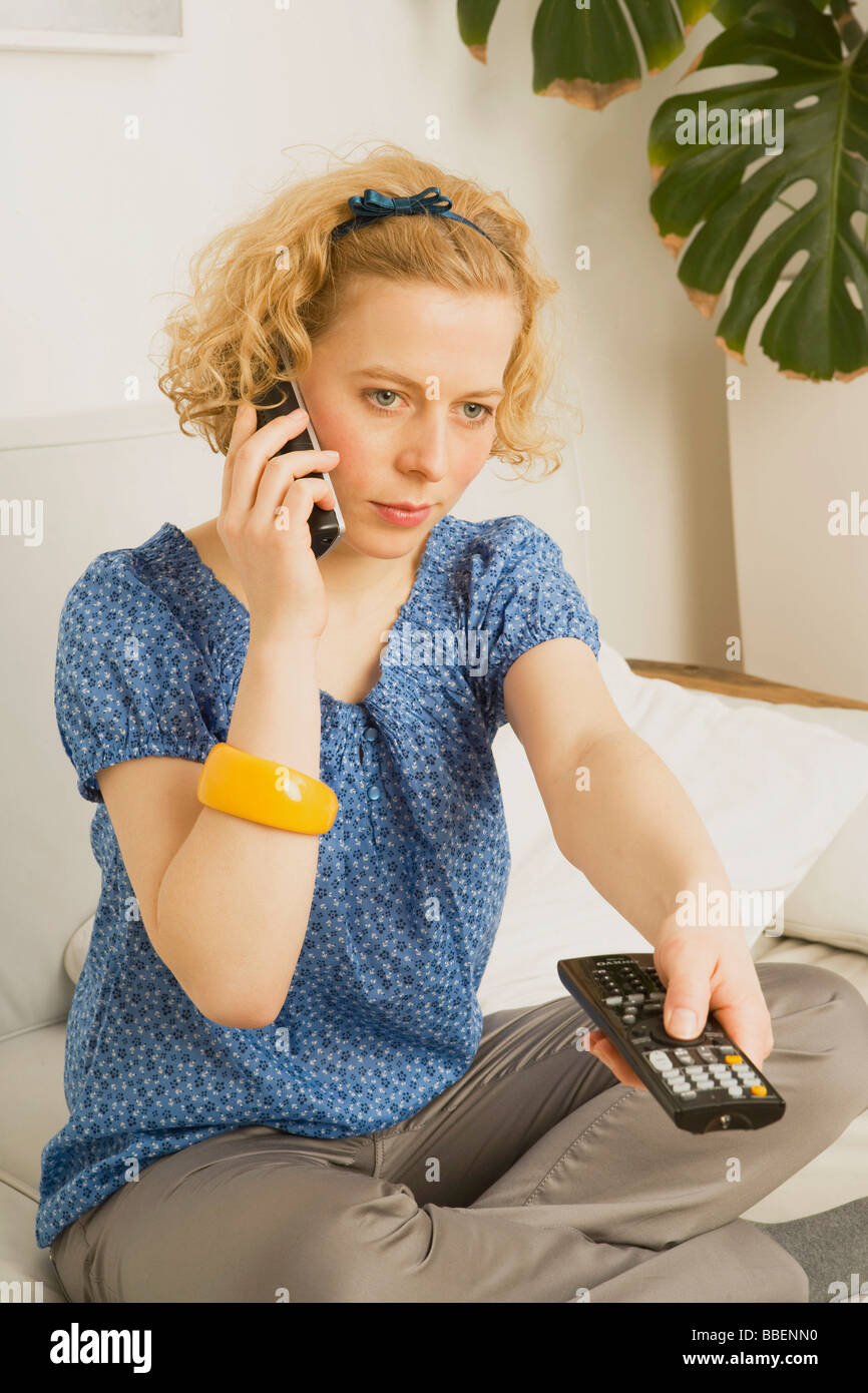 Woman using TV Remote Stock Photo - Alamy