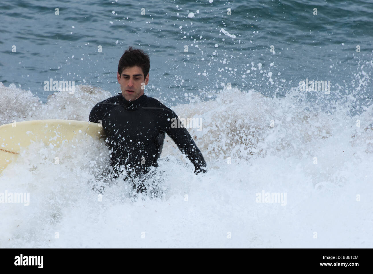 Young man inside the sea with his surfboard Stock Photo - Alamy