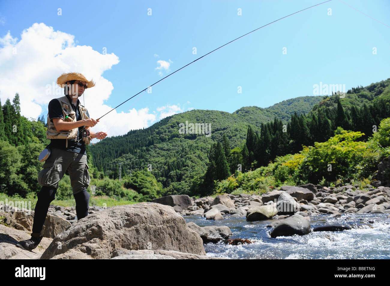 Man with straw hat fishing Stock Photo - Alamy