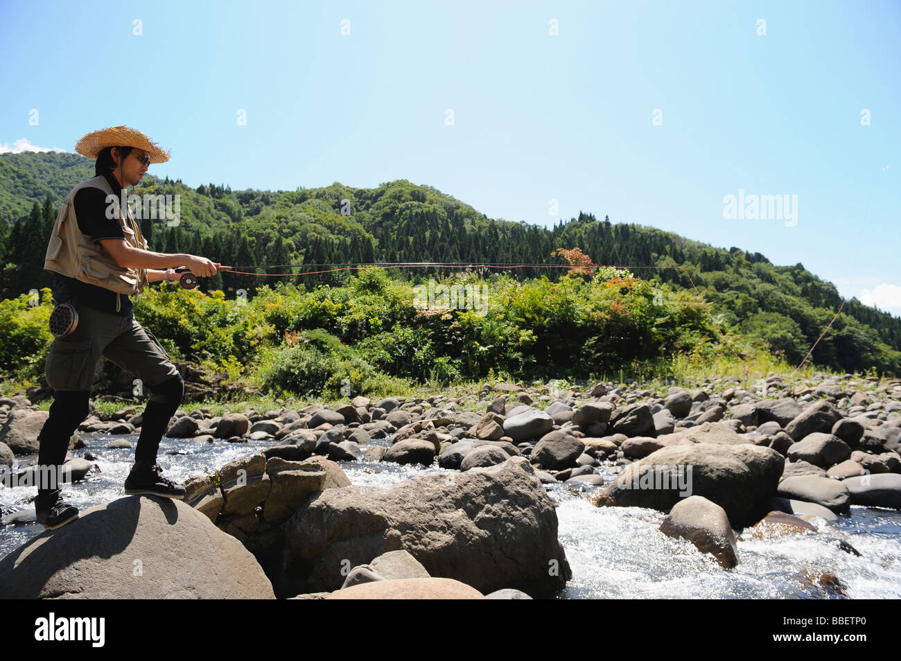 Man with straw hat fishing Stock Photo - Alamy