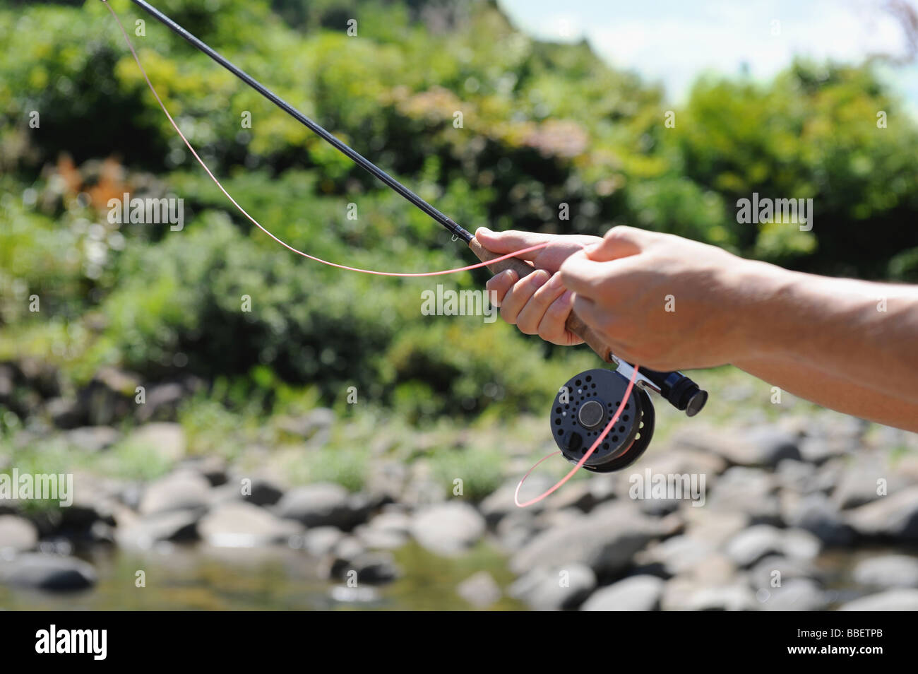 Hands holding fishing rod Stock Photo - Alamy