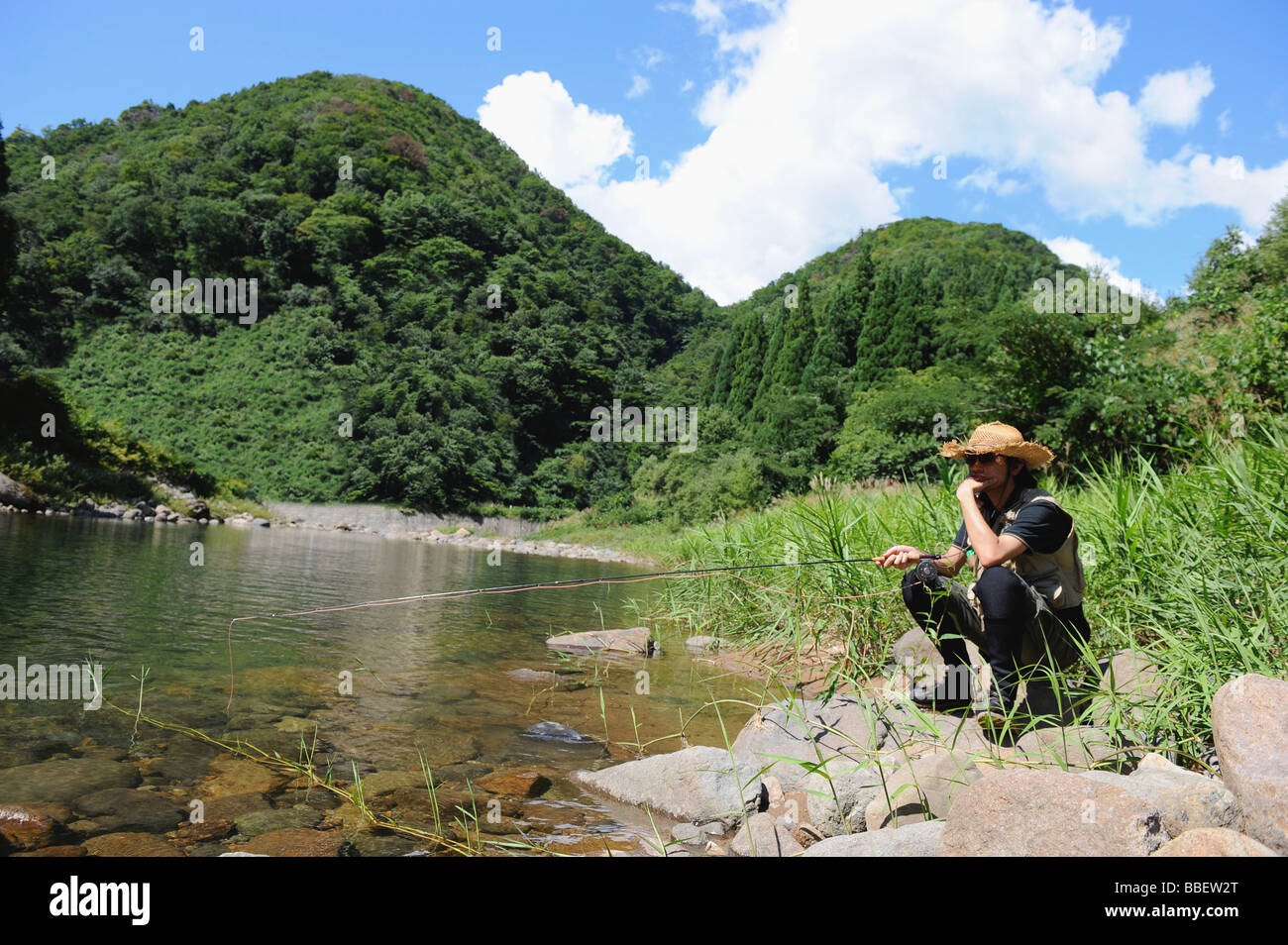 Man with straw hat fishing Stock Photo - Alamy