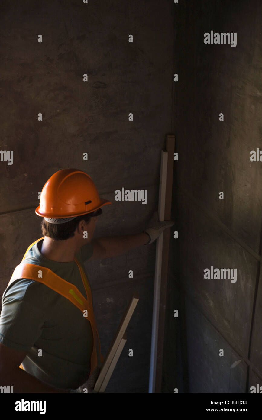Construction worker placing wood in corner Stock Photo - Alamy