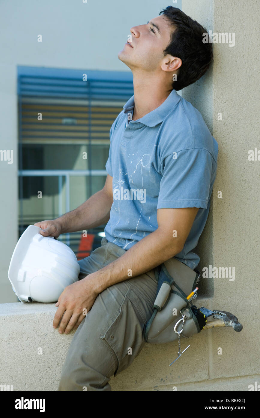 Man sitting on ledge, leaning head back, looking up Stock Photo - Alamy