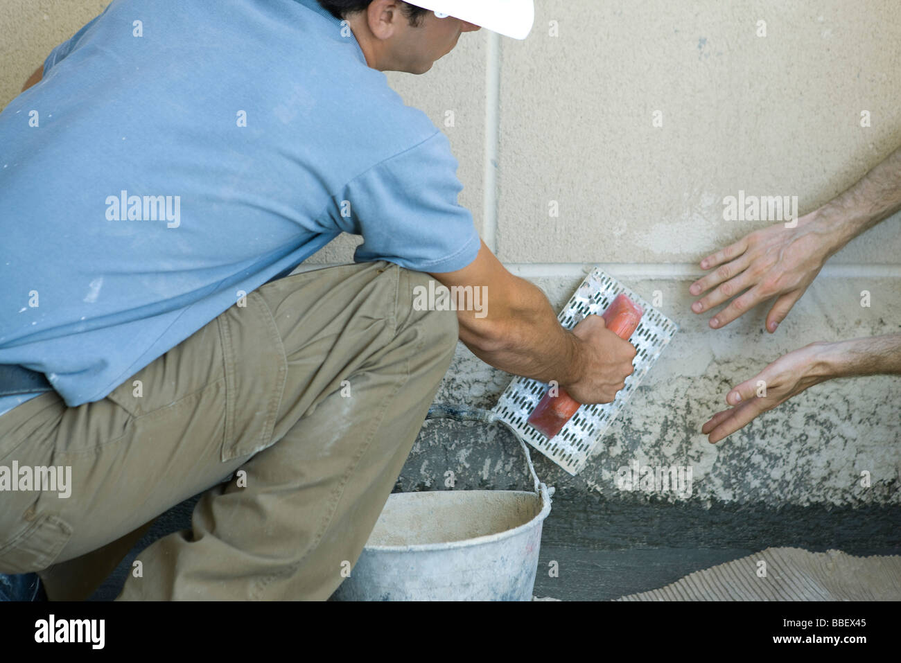 Mason receving guidance on proper masonry technique Stock Photo - Alamy