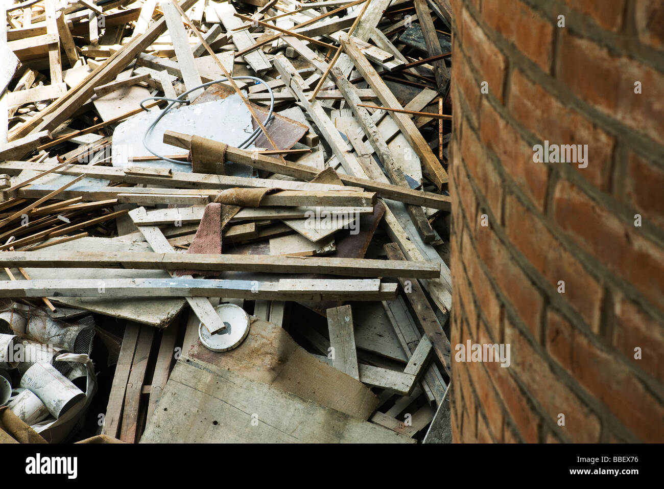 Pile of demolition debris, wood, pipe, wires next to brick wall Stock ...