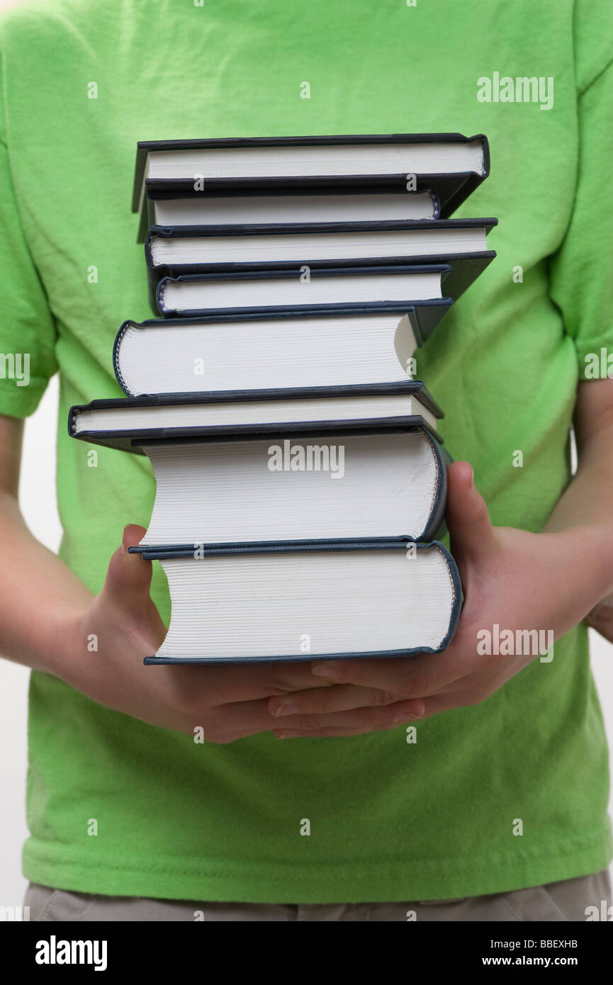 Young boy holding a stack of books Stock Photo - Alamy