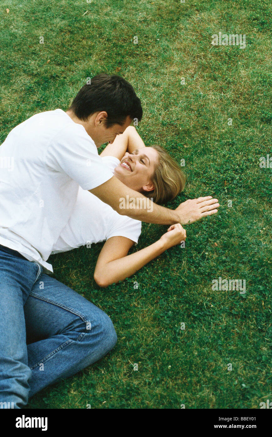 Couple lying together on ground, high angle view Stock Photo - Alamy