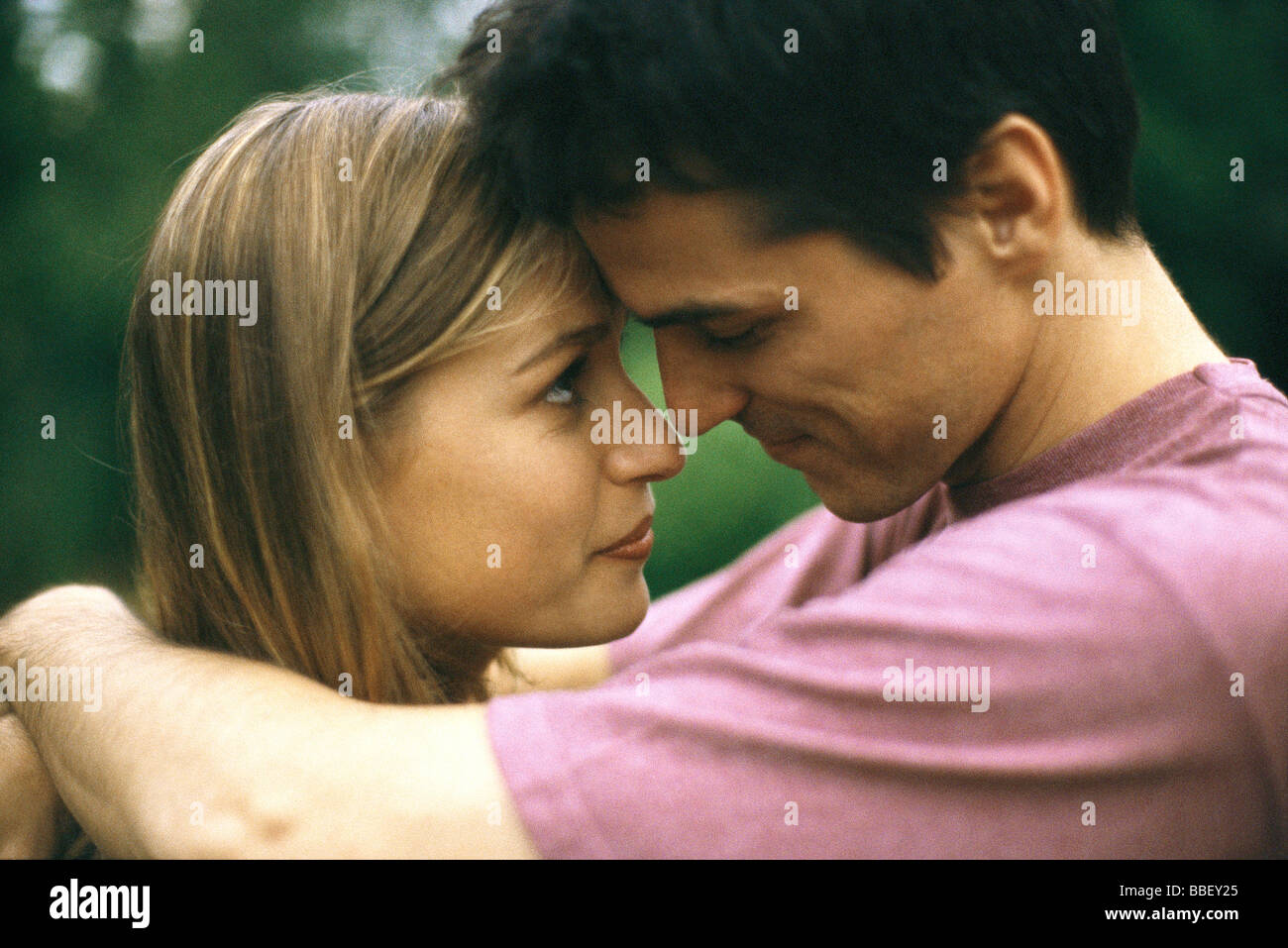 Couple embracing, touching foreheads, side view Stock Photo - Alamy
