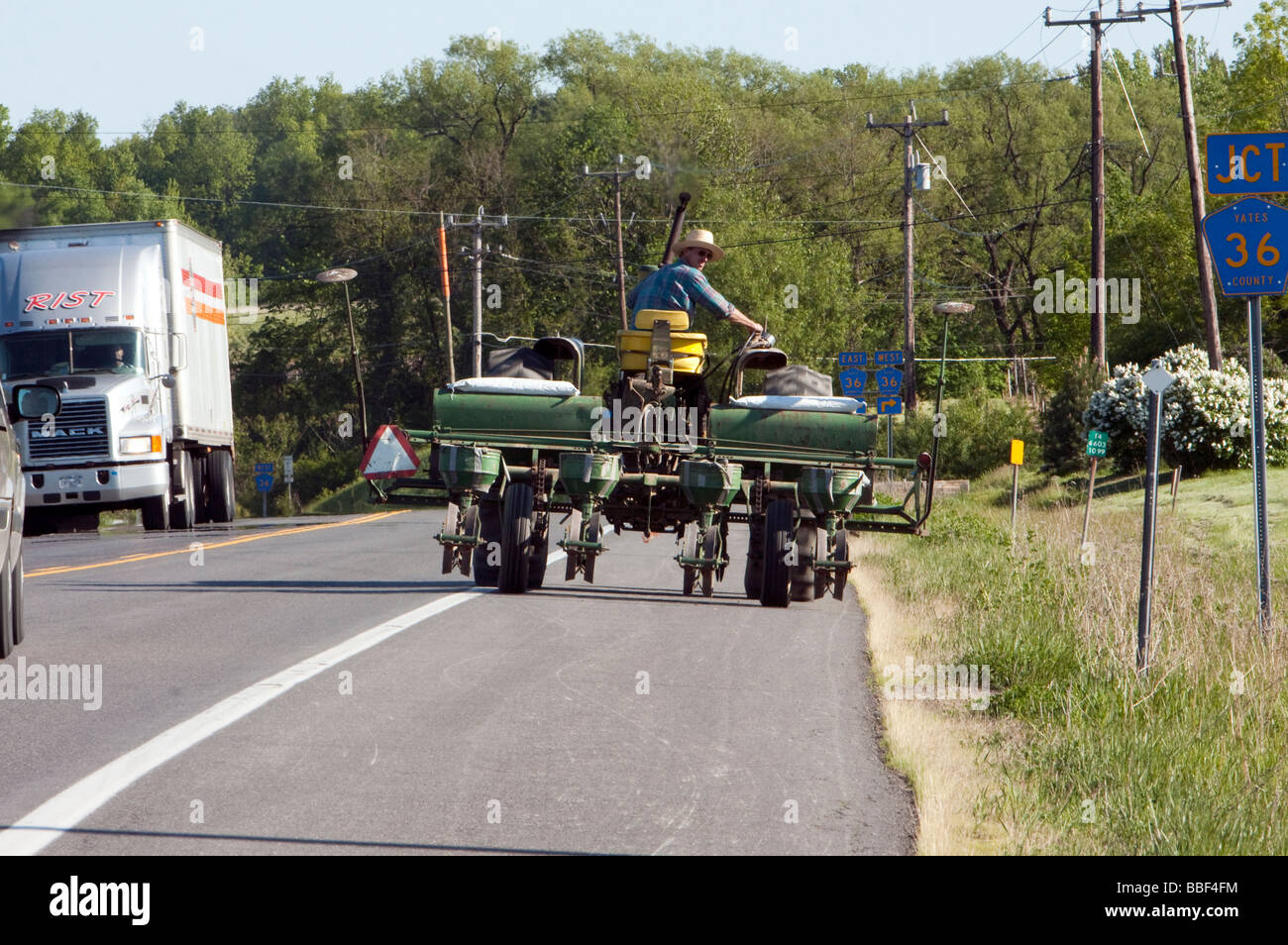 A tractor driving on the side of the road Stock Photo - Alamy
