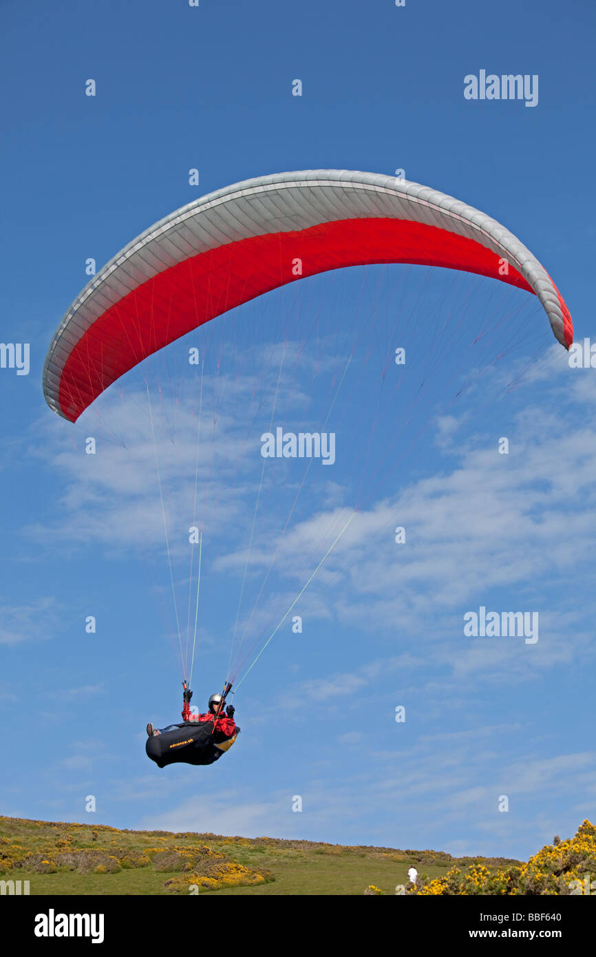 Red white paraglider over cliffs Rhossili Bay The Gower South Wales UK ...