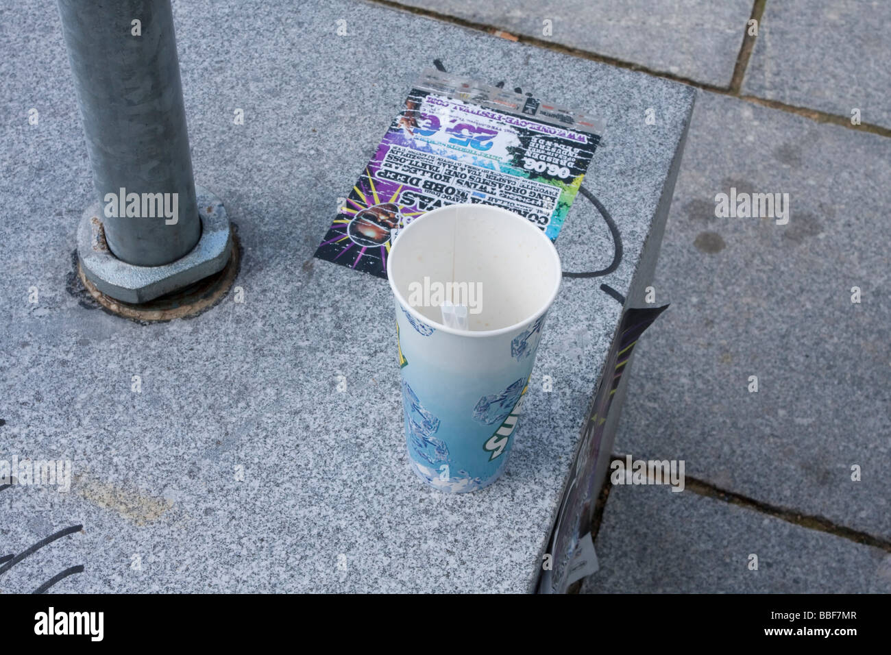 Discarded cup and flyer on an urban sidewalk Stock Photo - Alamy