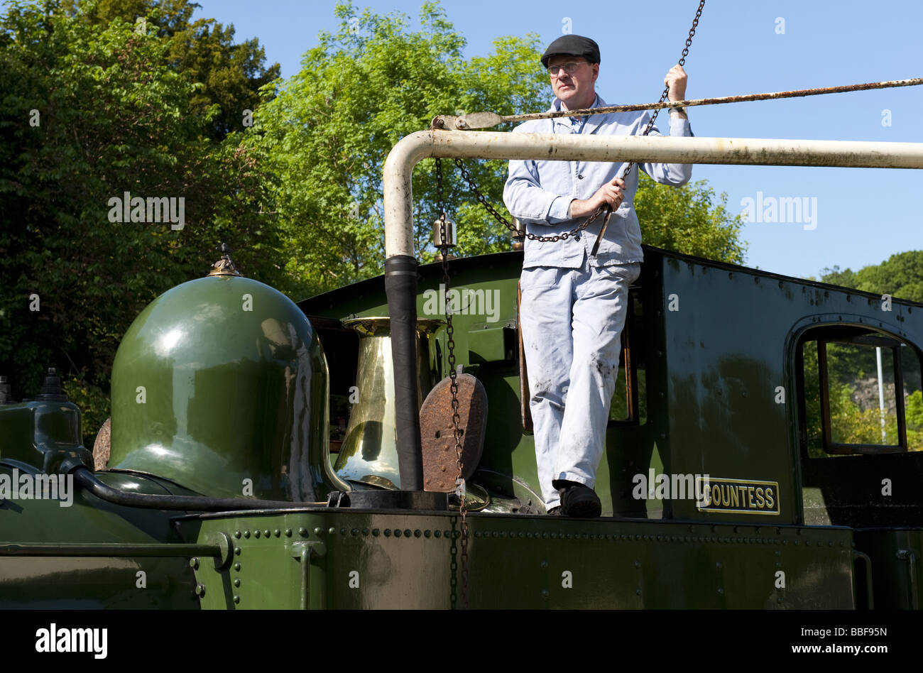 Volunteer train driver/engineer refilling the Countess steam engine ...