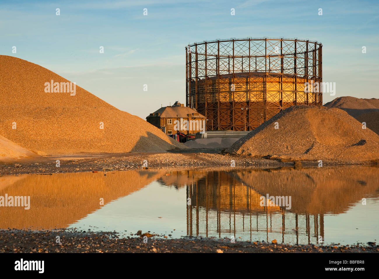 Gas reservoir sand and gravel with reflection against blue sky Stock ...