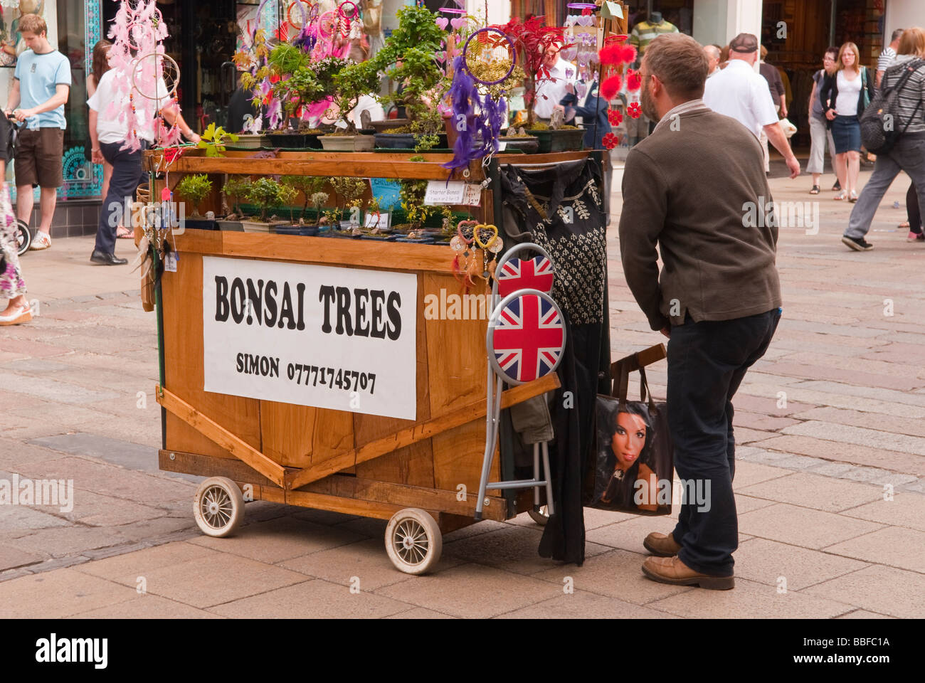 A street trader man selling Bonsai trees from a mobile barrow in the ...