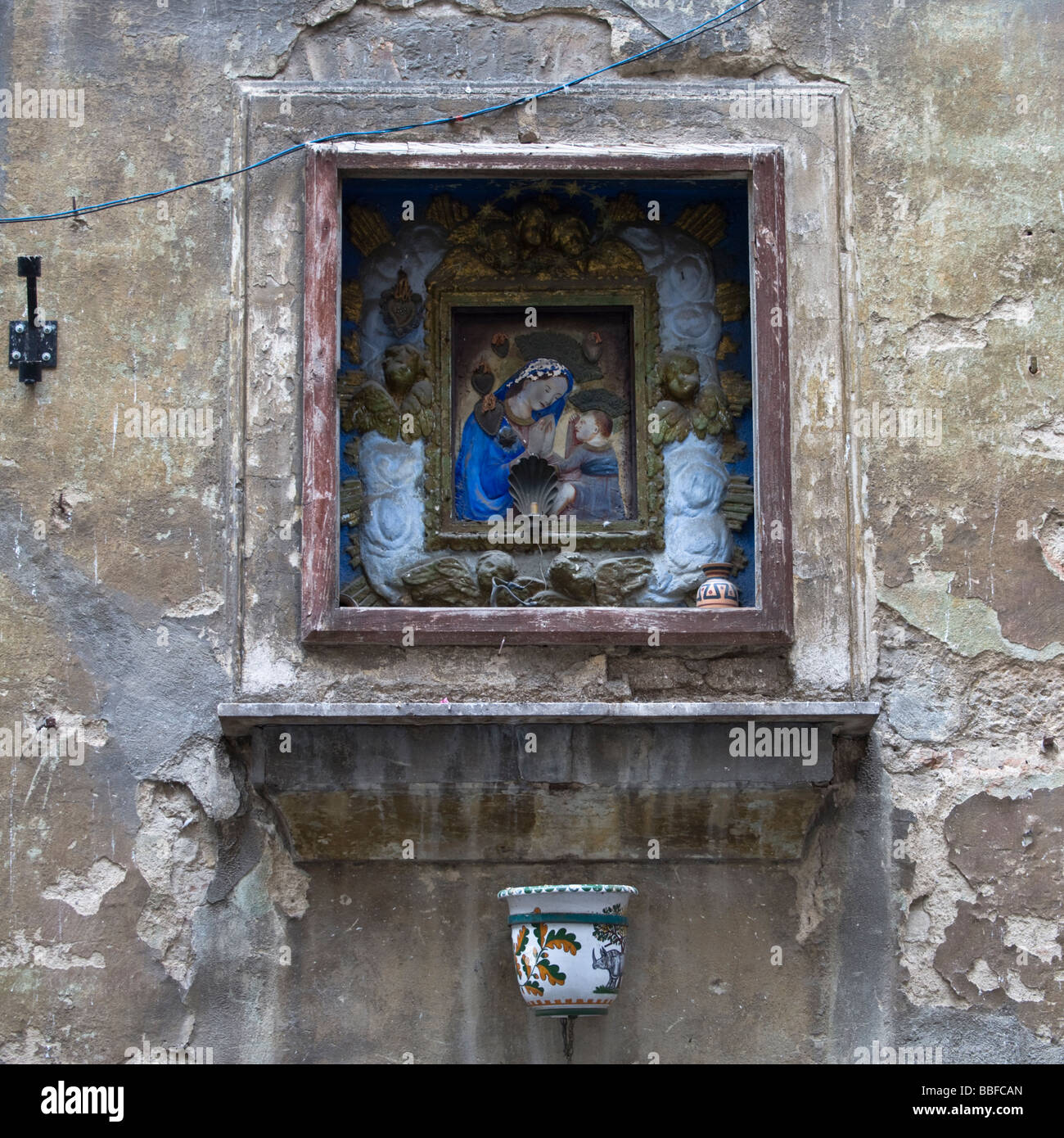 Crumbling religious devotional shrine of the Madonna & child in the ...