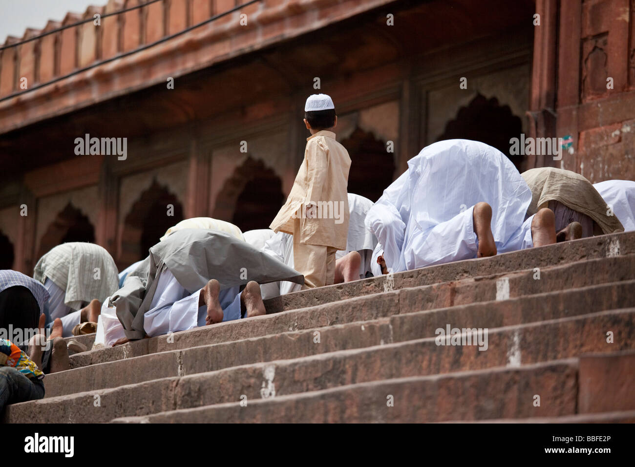 Men Praying on the Steps of the Jama Masjid as a Young Boy Looks on in ...