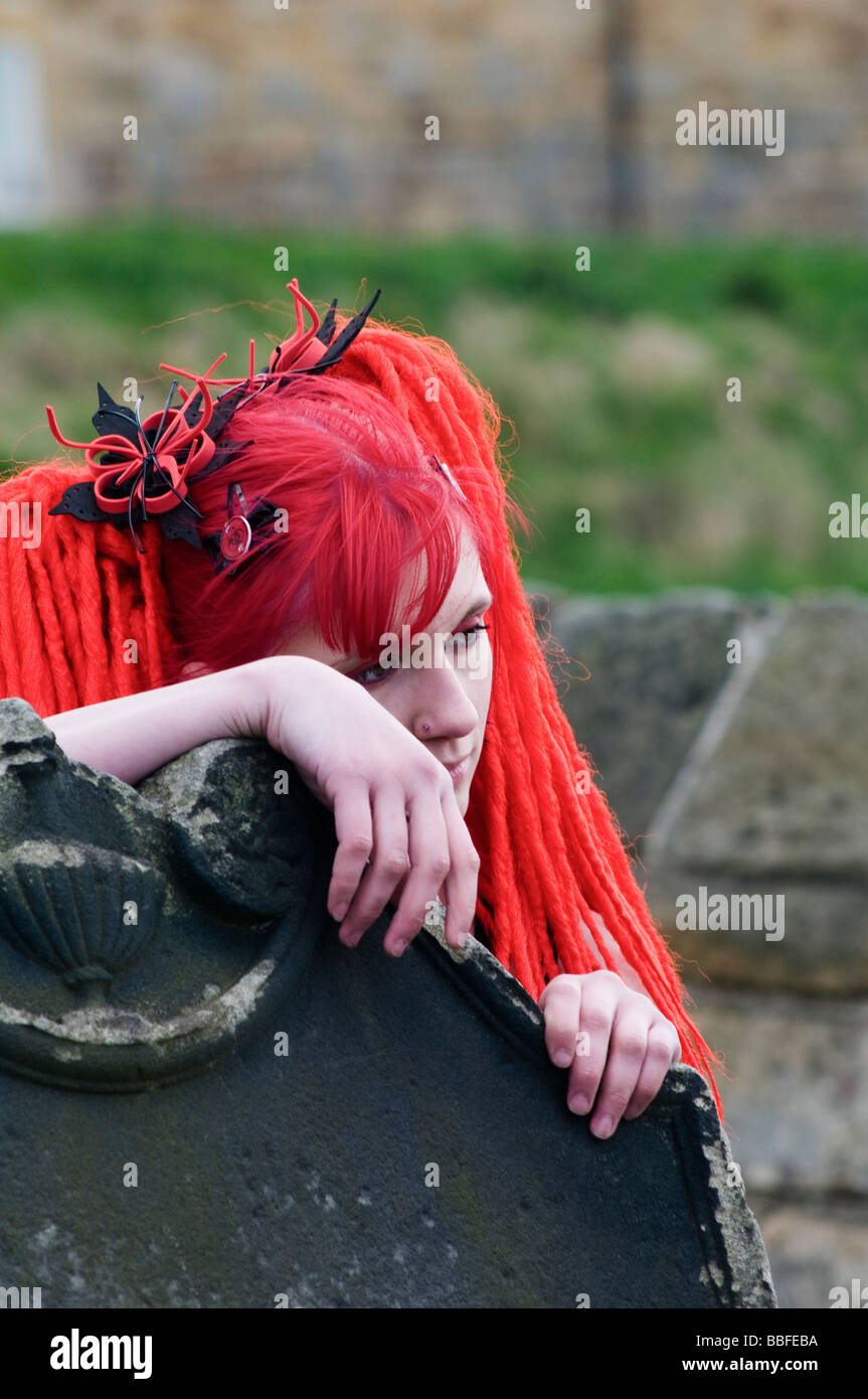 A Goth with dyed red hair in the grounds of St Mary's Church, Whitby ...