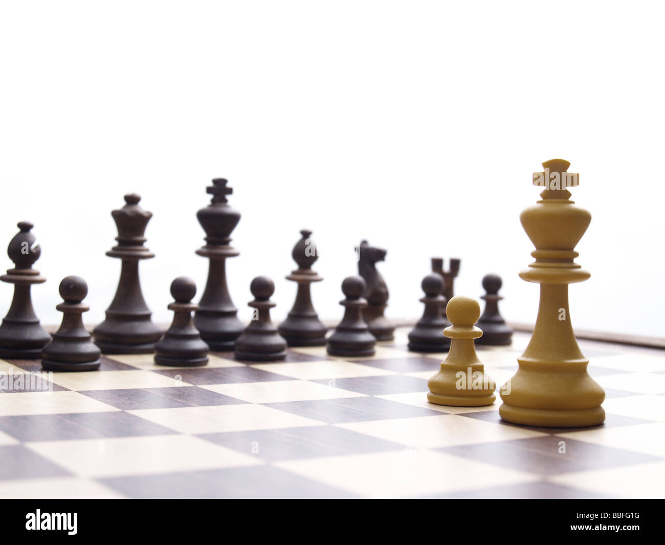 lonely white king and pawn facing black chessmen on chess board white ...