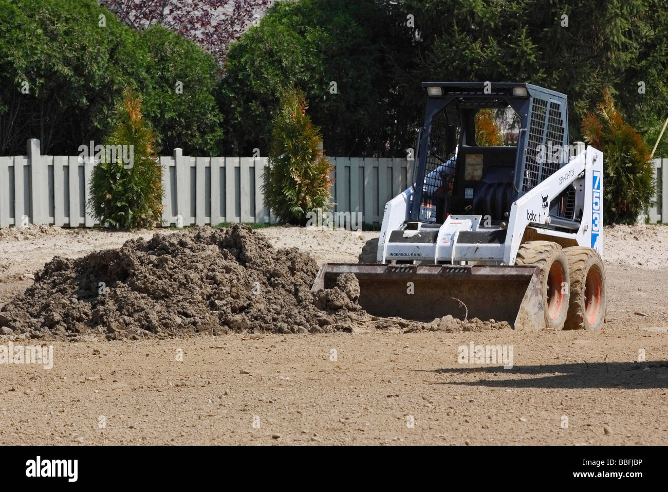 Landscaping on a garden with a small bulldozer nobody none horizontal ...
