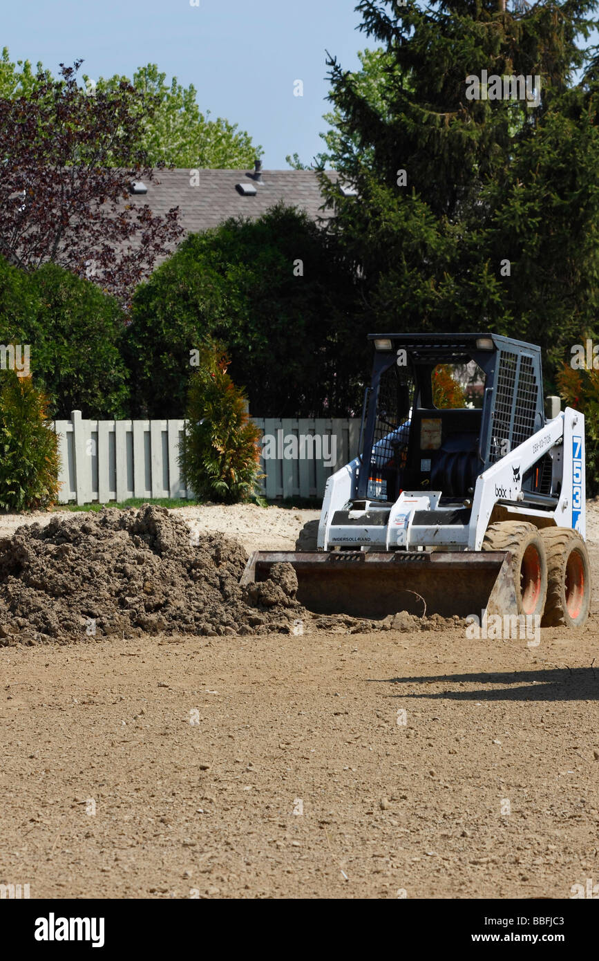 Landscaping on a garden with a small bulldozer nobody none vertical in ...