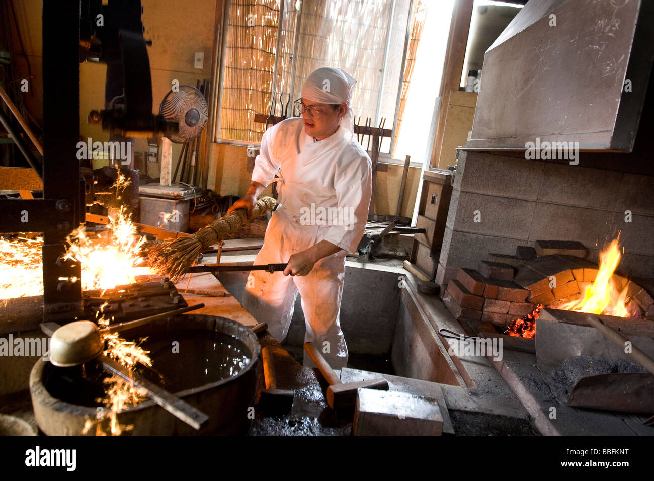 Sadanori Tanaka a swordsmith for 18 years works on a sword in his forge ...