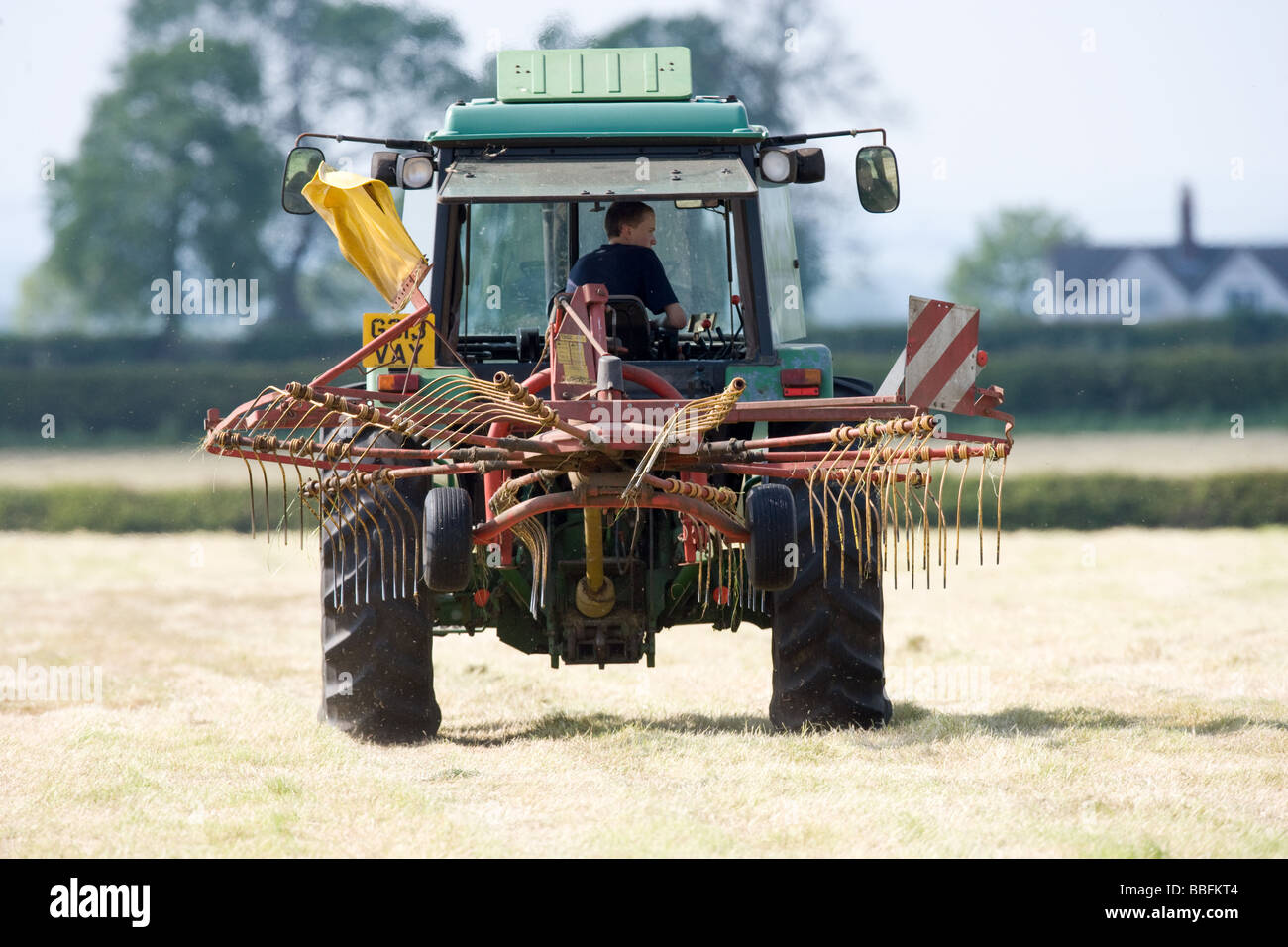 Tractor Turning Grass Ready To Make Silage Stock Photo - Alamy