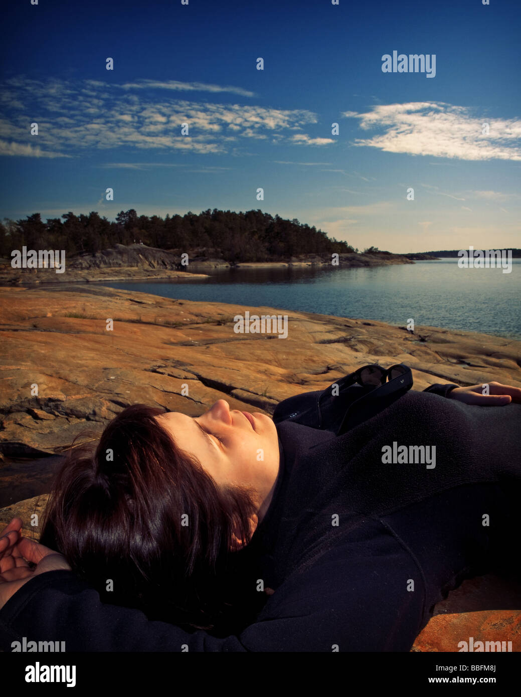 Woman sunbathing on rocks hi-res stock photography and images - Alamy