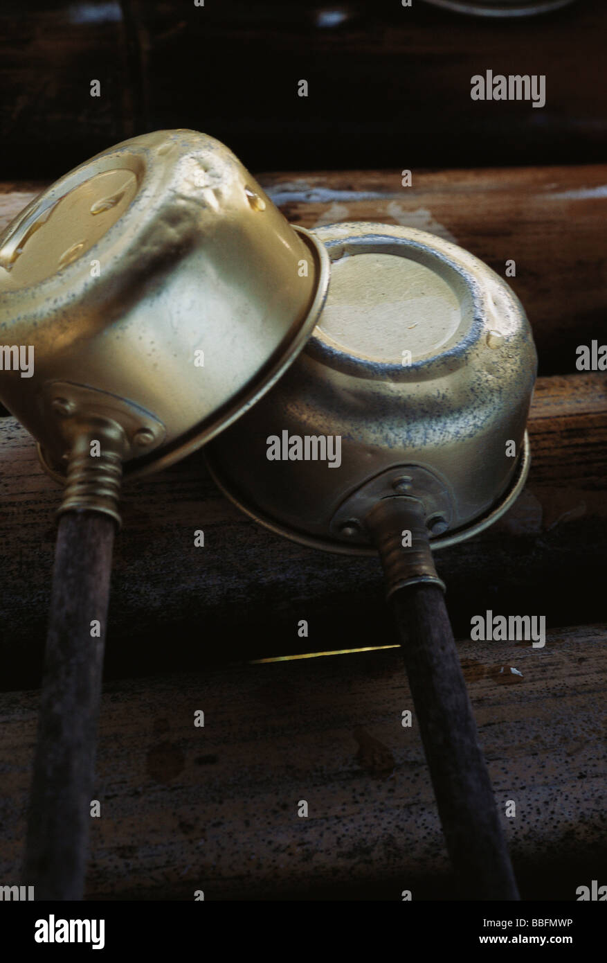 Wet cooking pots, upside down, one leaning against the other drying ...