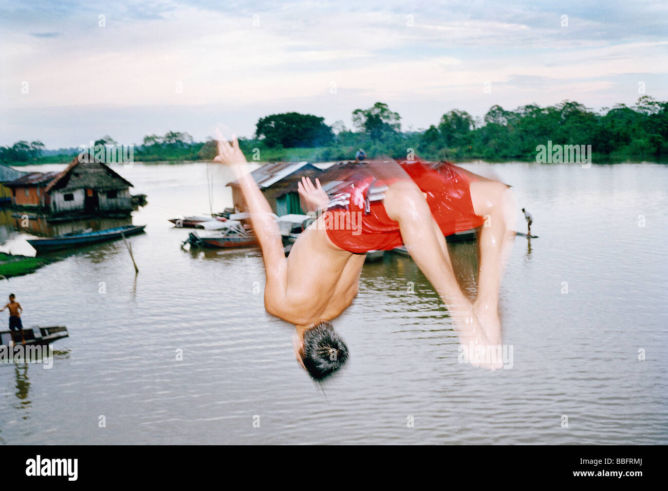 A boy jumping to Amazon river in small riverside village of Pevas ...