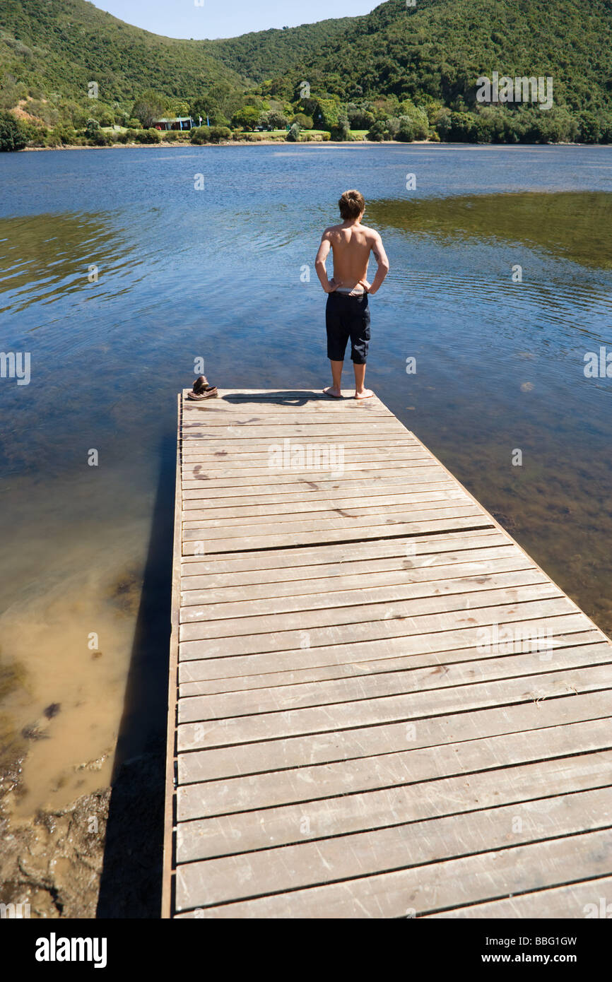 Teenage boy on a jetty Stock Photo - Alamy