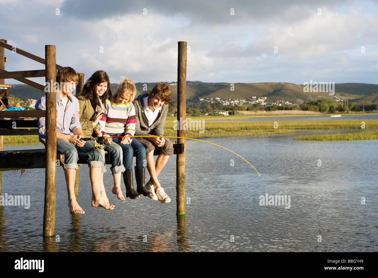 Friends on a jetty Stock Photo - Alamy