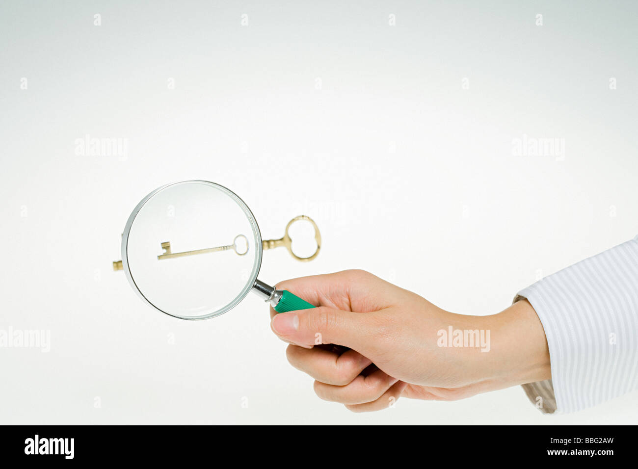 Person magnifying key Stock Photo - Alamy