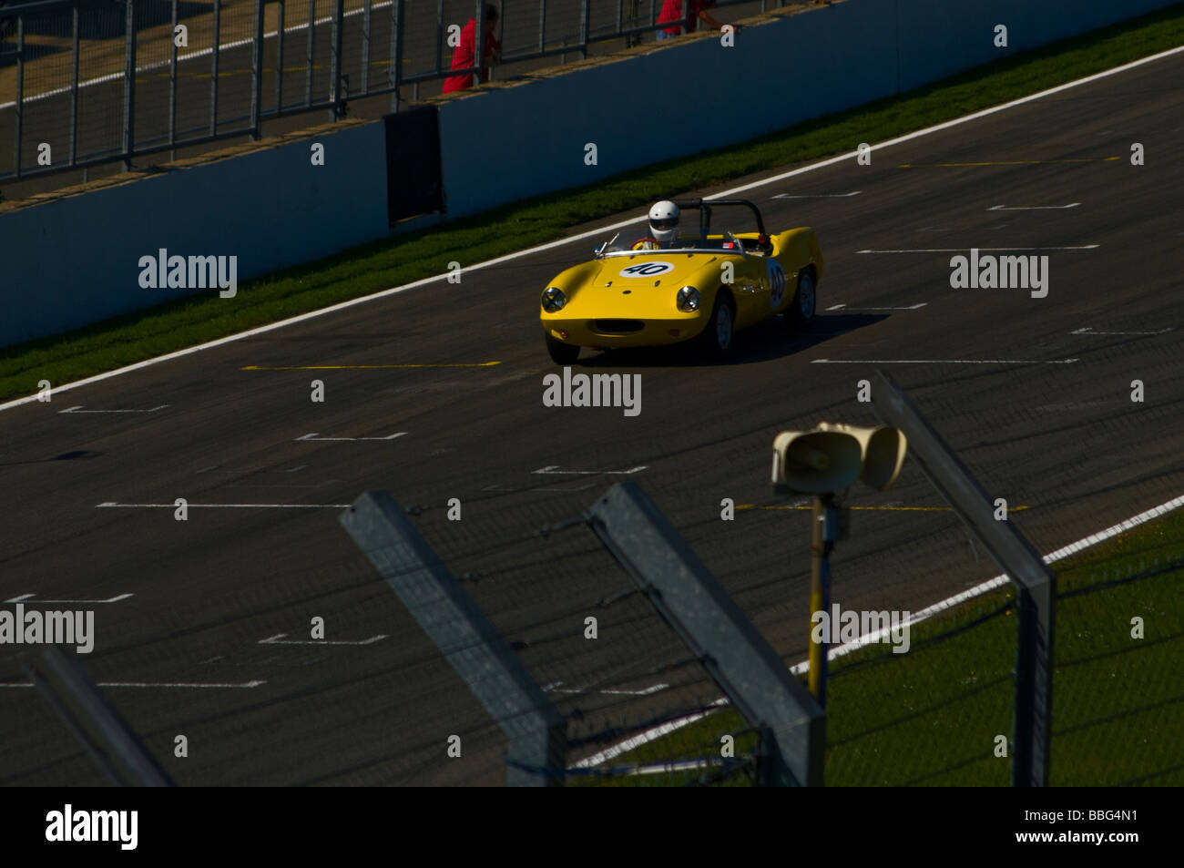 A Yellow 1960 Elva Courier driven by Trevor Kemp Racing Along Brabham ...