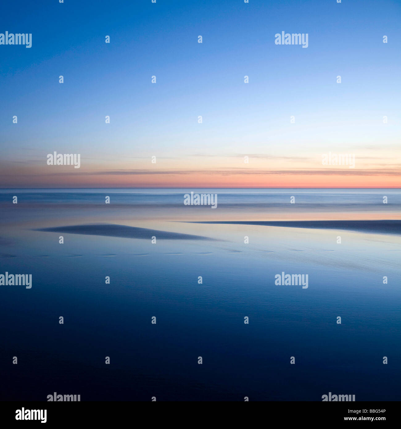 Sunset over beach Stock Photo - Alamy