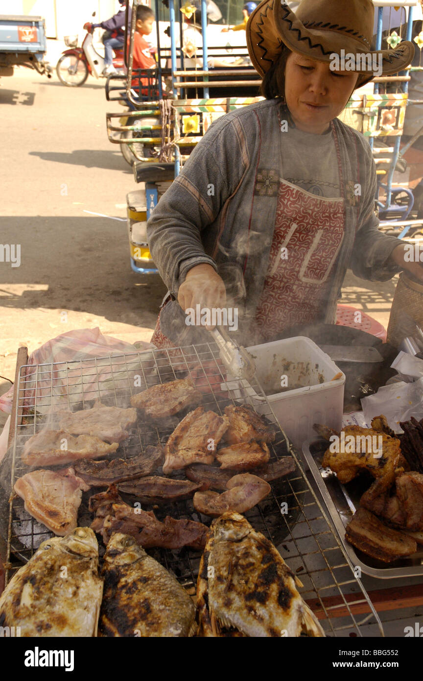 Laotian woman grilling chicken in a market of Vientiane, Laos Stock ...