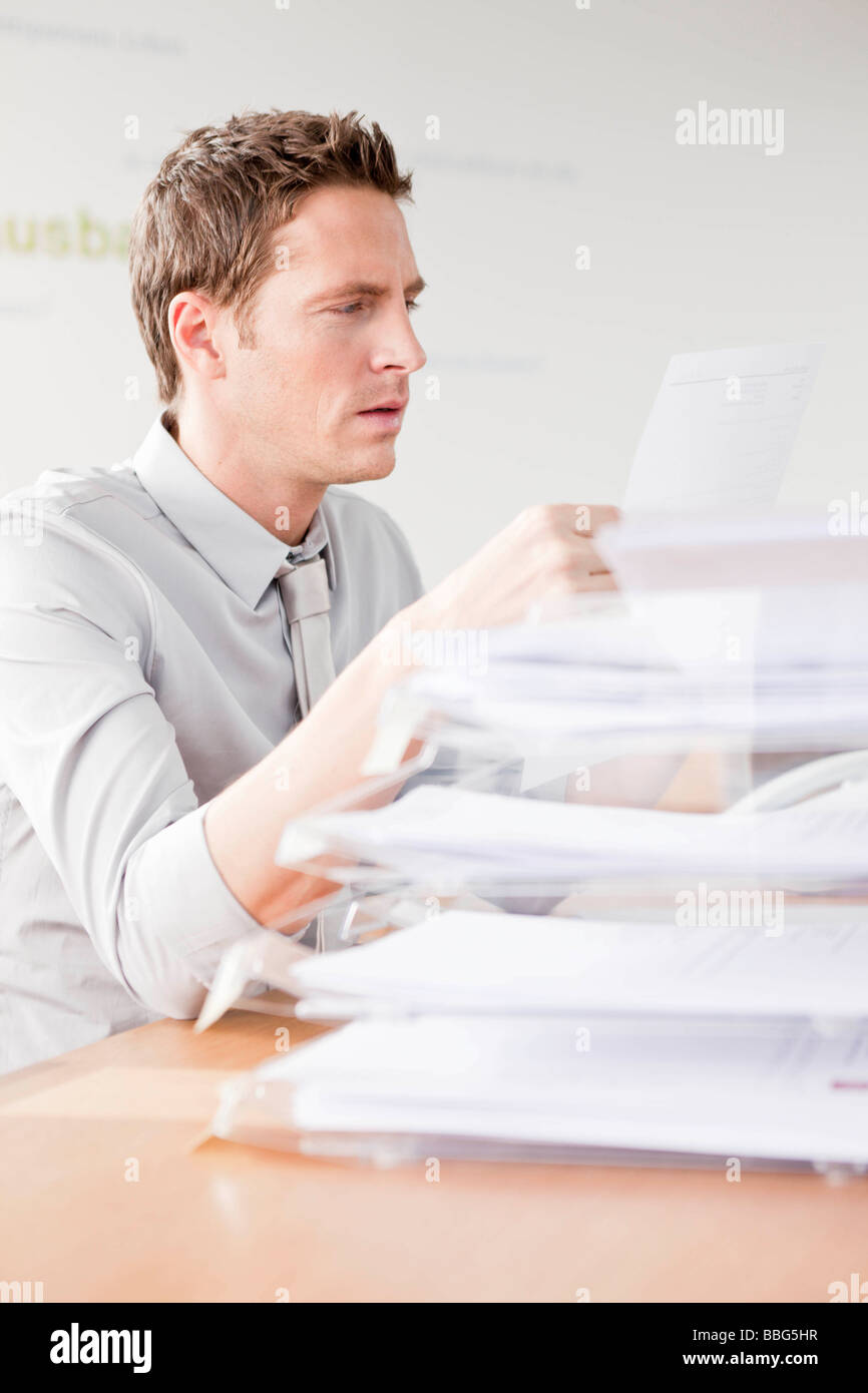Man looking at papers Stock Photo - Alamy