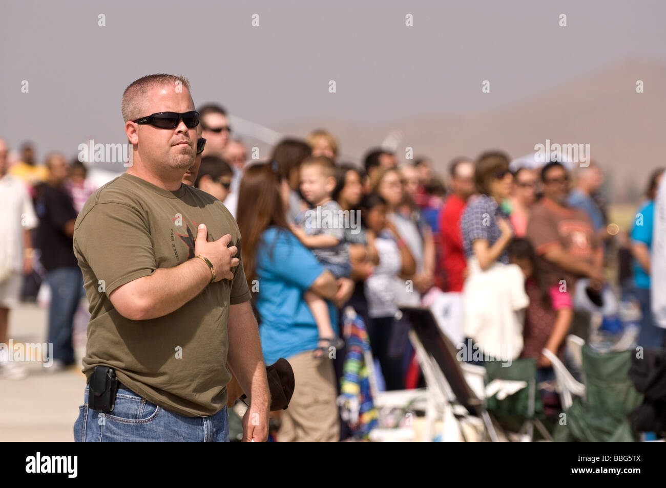 A man stands with his hand over his heart as she states the Pledge of ...