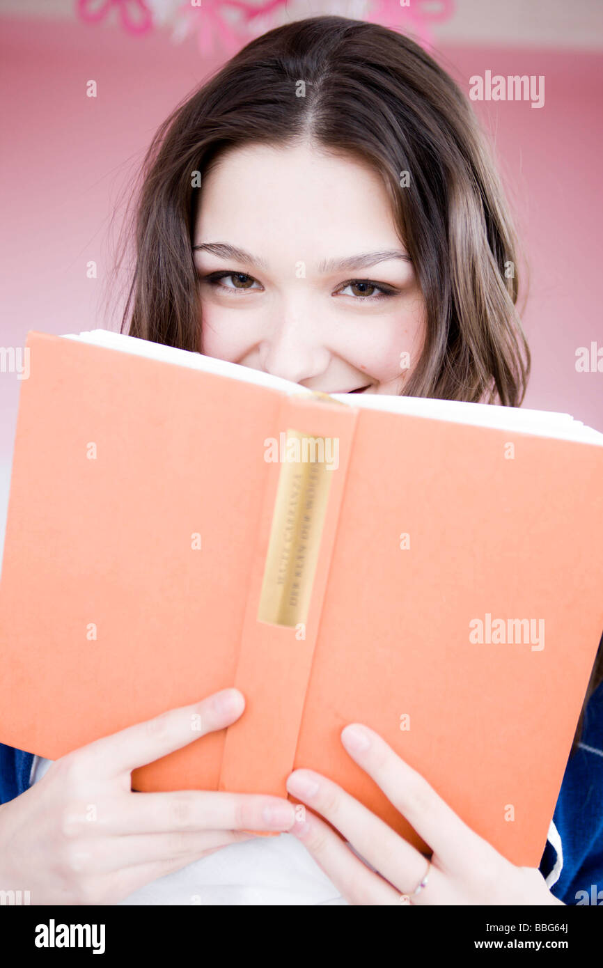 Girl looking at viewer with book Stock Photo - Alamy