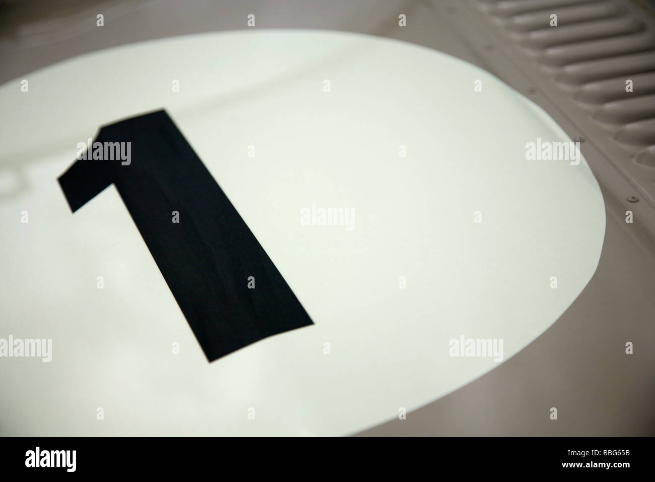 Number 1 in white circle on grey background Stock Photo - Alamy