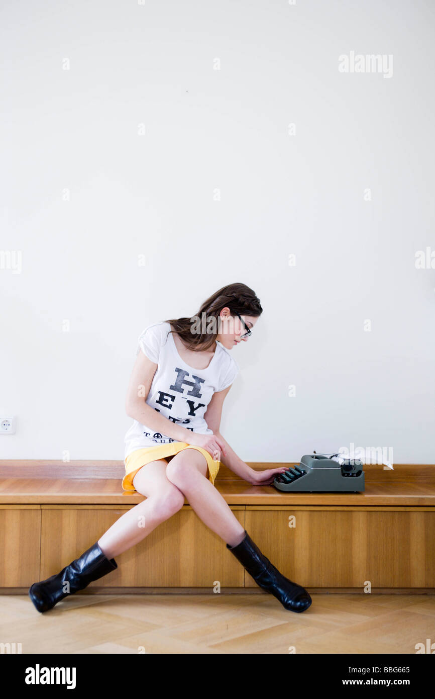 Girl sitting on bench with typewriter Stock Photo - Alamy