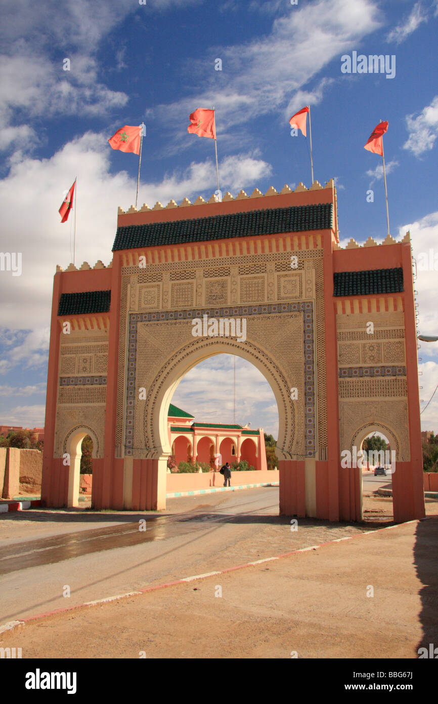 Morocco's flags fly over the keyhole arch entrance to Rissani; a desert ...