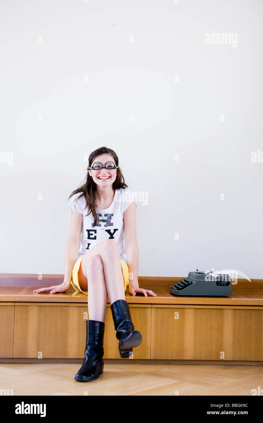 Girl sitting on bench with typewriter Stock Photo - Alamy