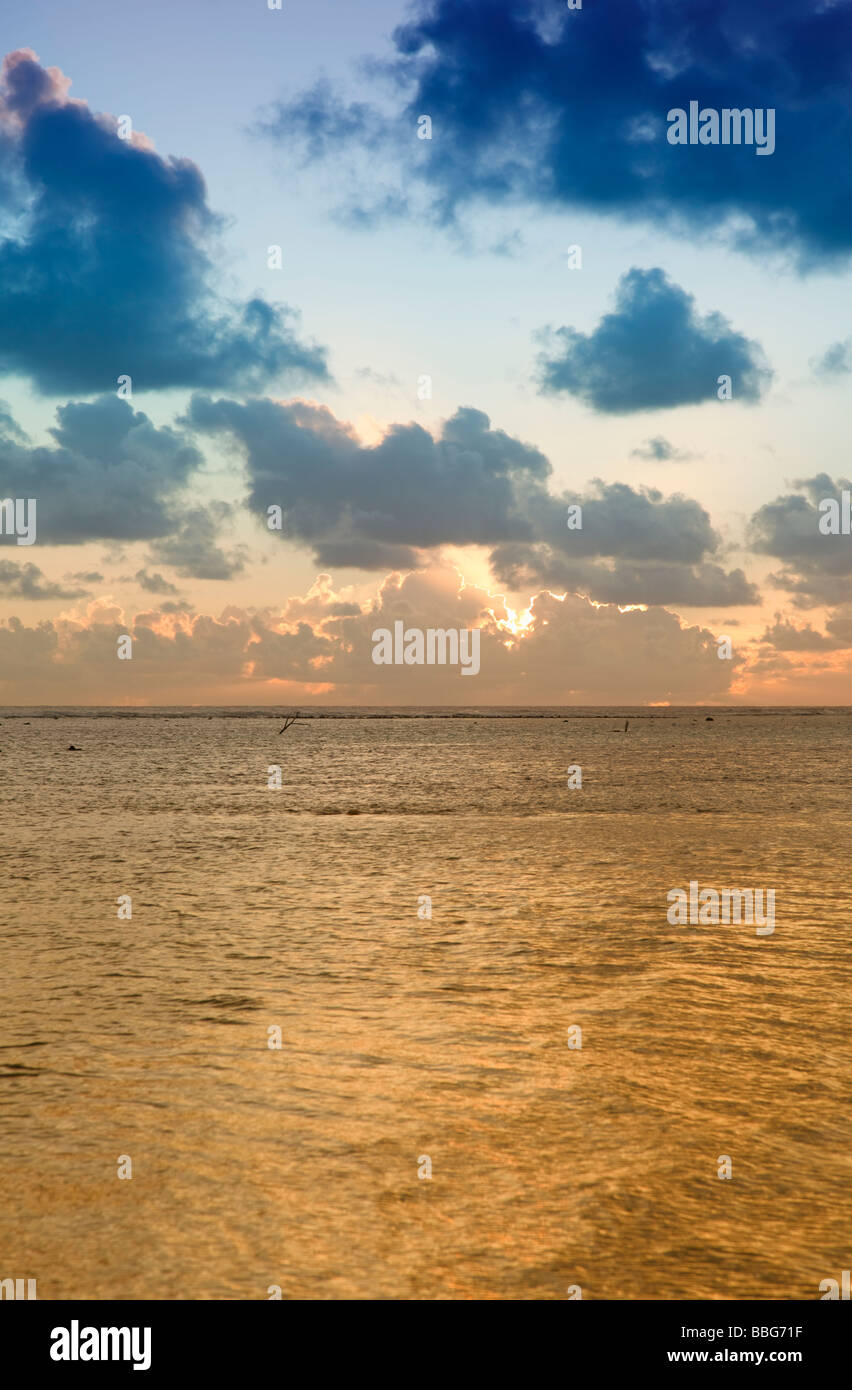 Sun sinks to Sea under a cloud filled Sky at Sunset Rarotonga Cook ...