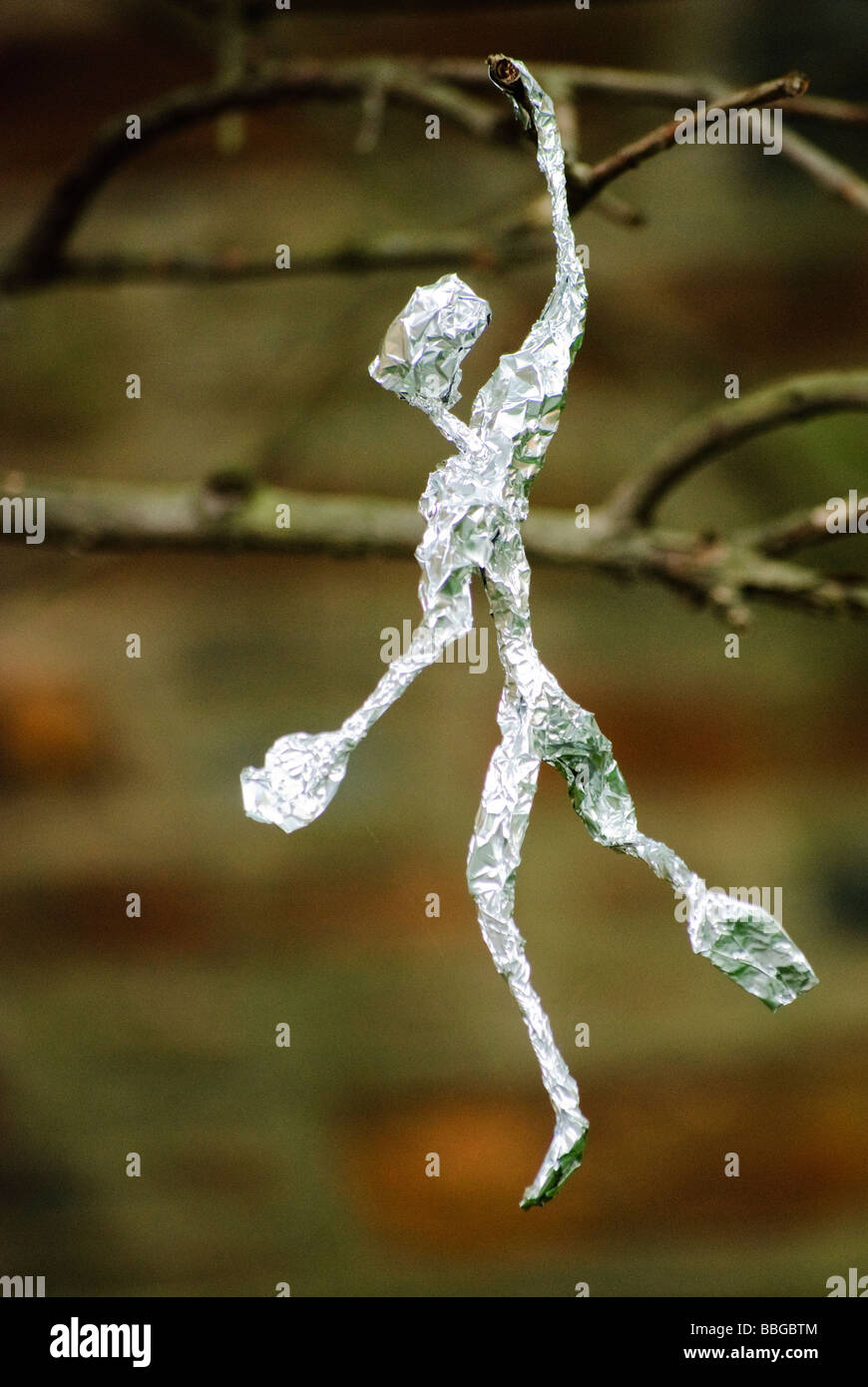 Stickfigure made of tinfoil hanging from a tree branch Stock Photo - Alamy