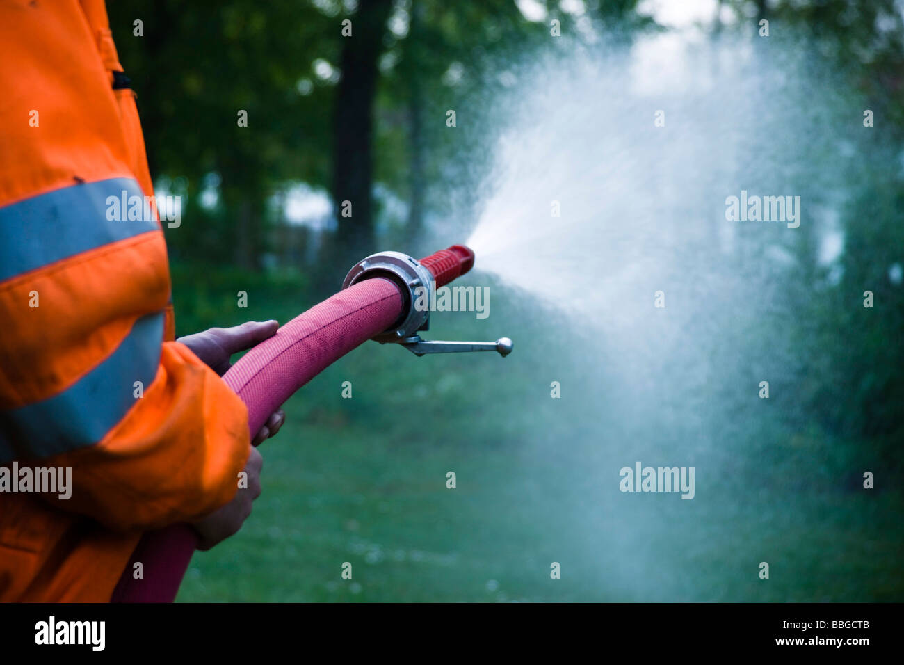 Firefighter watering the dry forest Stock Photo - Alamy